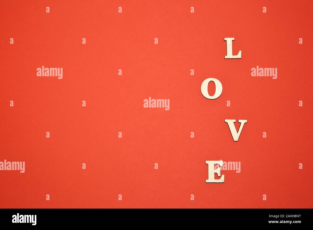 Wooden decorative letters in word LOVE put vertically isolated on pink ...