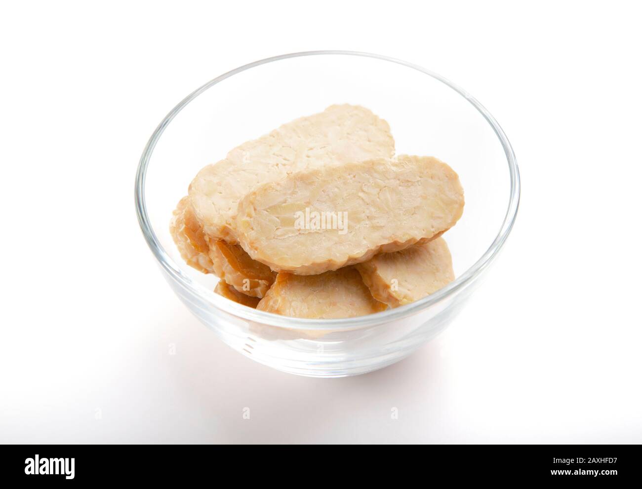 Tempeh slices in glass bowl on white background Stock Photo - Alamy
