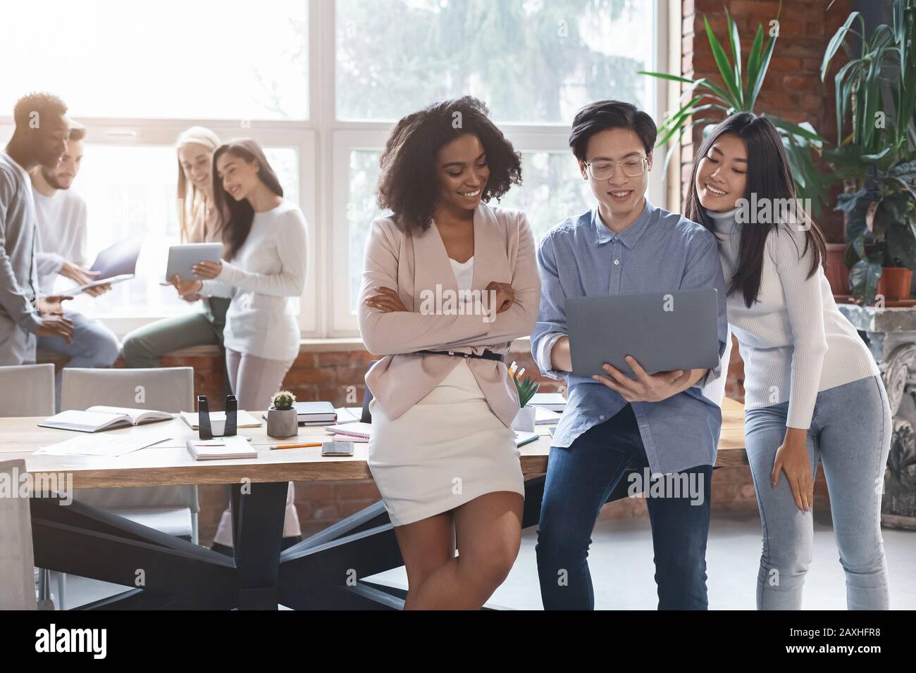 Diverse group of colleagues having conversation in office Stock Photo ...
