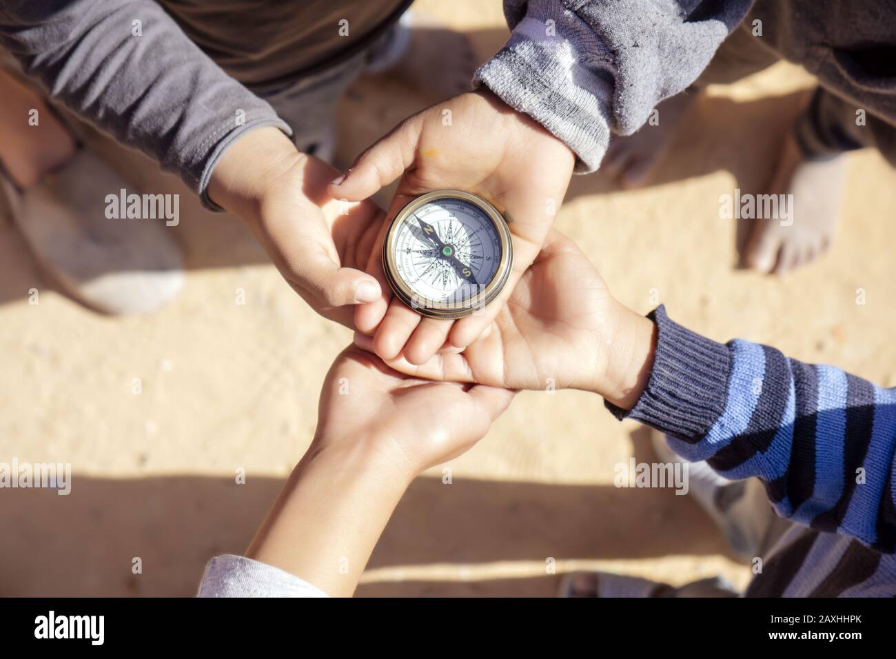 Group of children's hands holding a compass - teamwork concept Stock ...