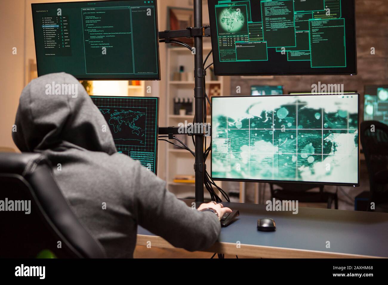 Cyber criminal wearing a hoodie writing a dangerous virus using ...