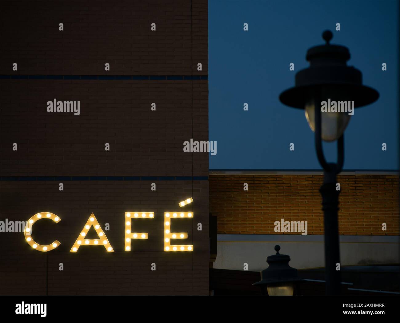 Word Cafe with lights on the wall in the street at night Stock Photo ...