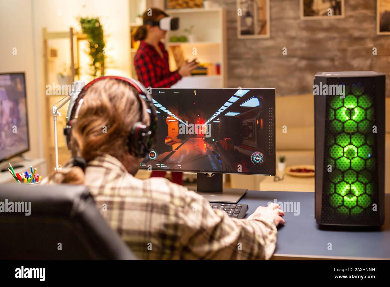 Back view of professional video gamer playing on powerful PC late at ...