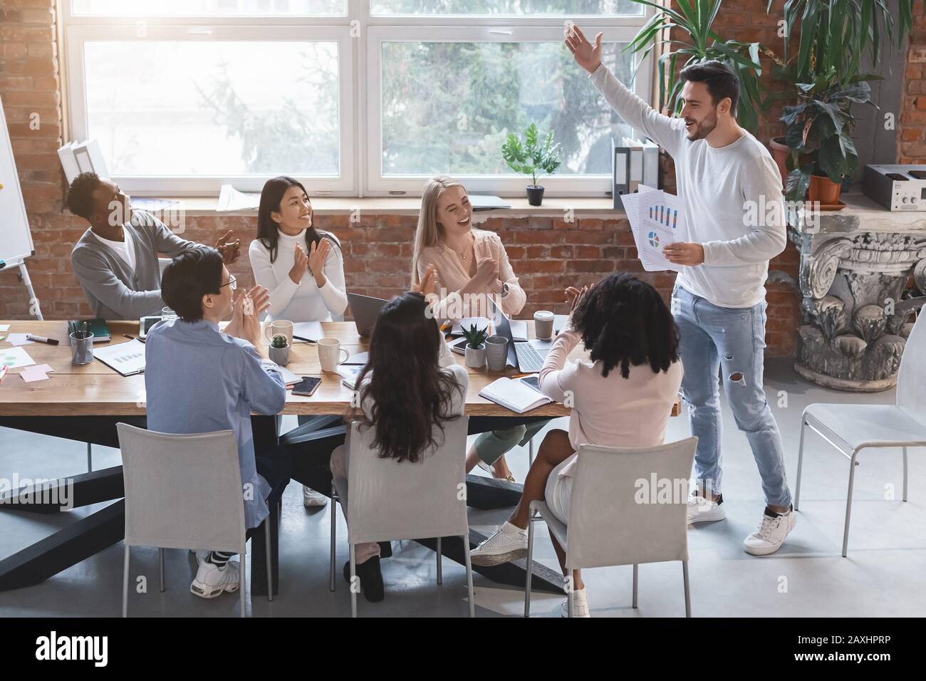 Young manager cheering up his young business team Stock Photo - Alamy