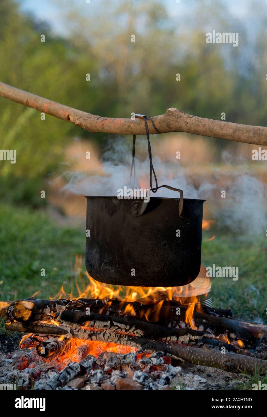 Black pot are heating under fire. Nature background is blur Stock Photo ...