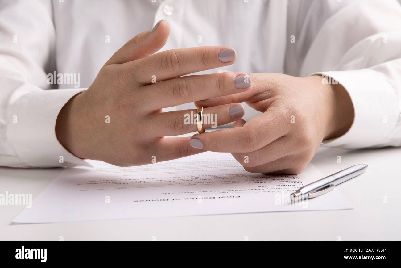 Wife in suit removing wedding ring from finger Stock Photo - Alamy