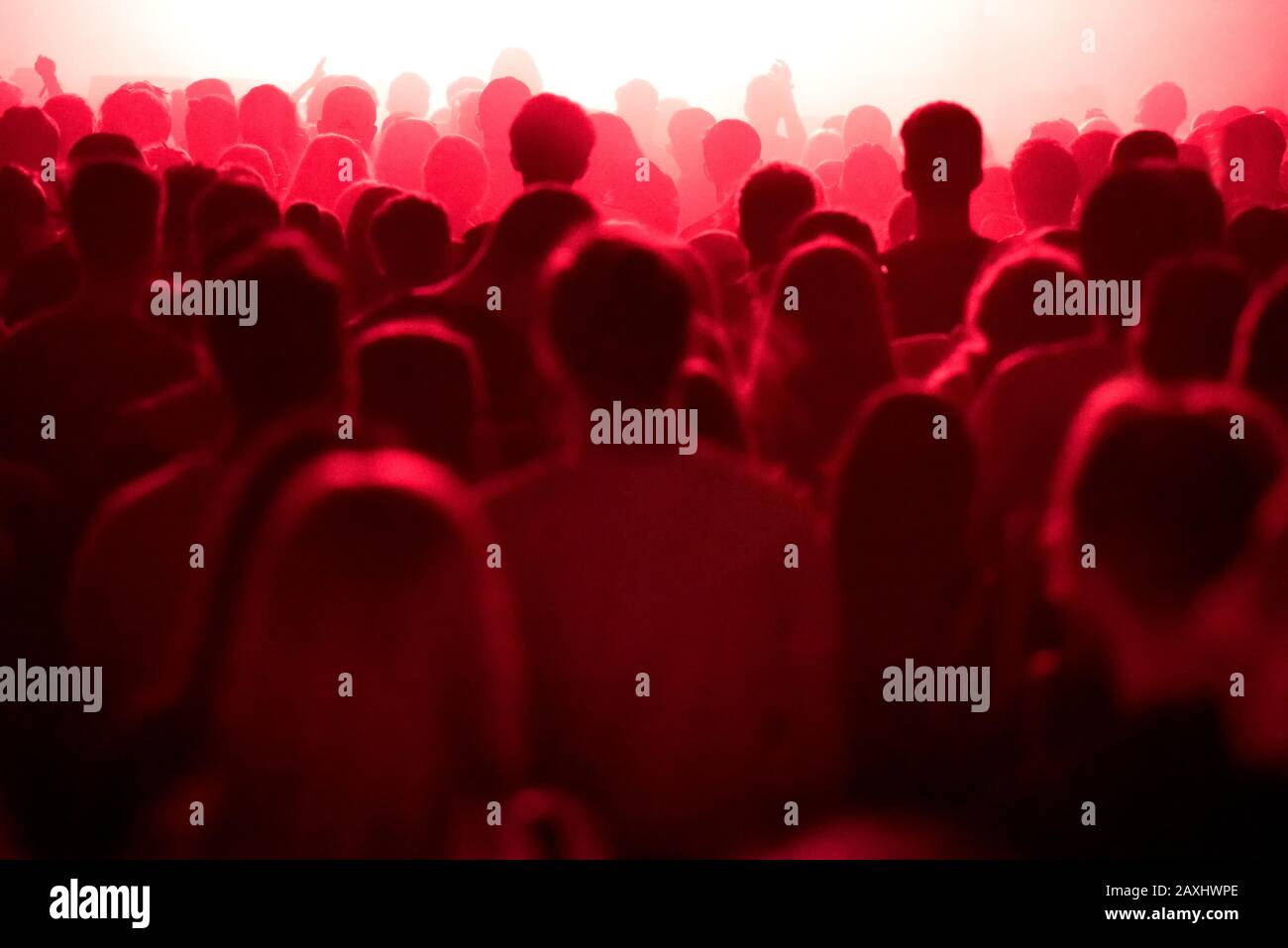 Cheerful people partying during live concert in red stage lights Stock ...
