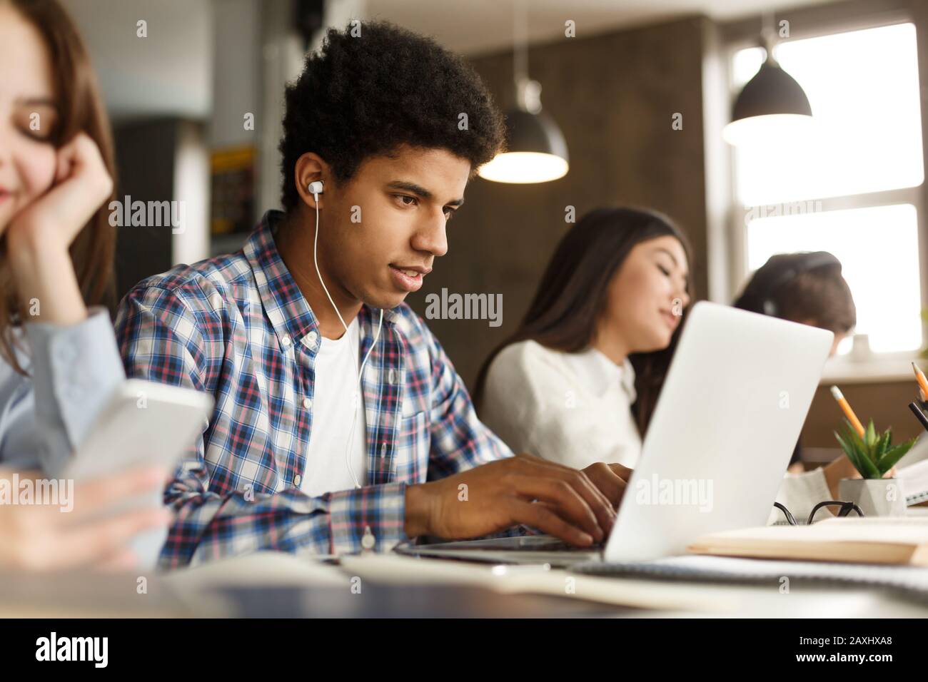 Afro student doing homework in college library Stock Photo - Alamy