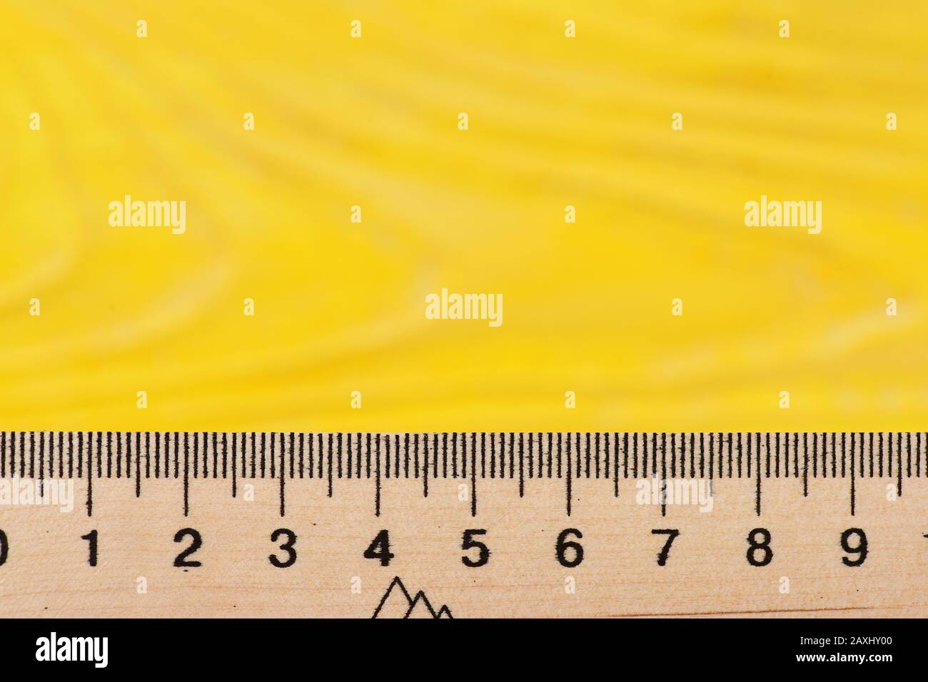 Wooden ruler close up on yellow background. Simple ruler with ...