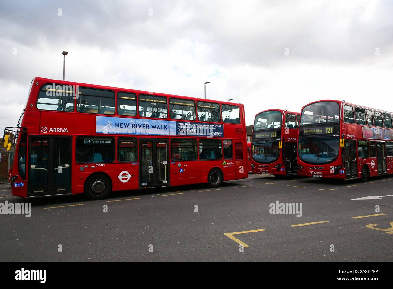 Red hybrid London buses at a London bus station Stock Photo - Alamy