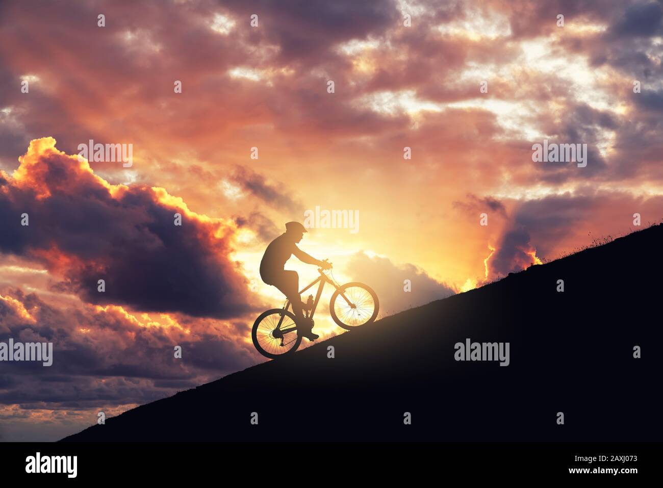 Riding mountain bike on a ramp against cloudy sky. Achieving the ...