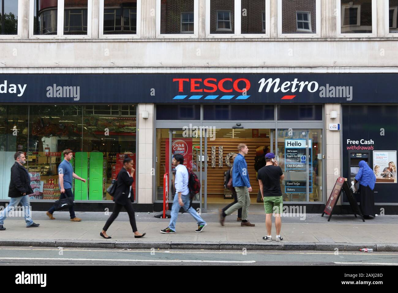 LONDON, UK - JULY 6, 2016: People walk by Tesco Express grocery store ...