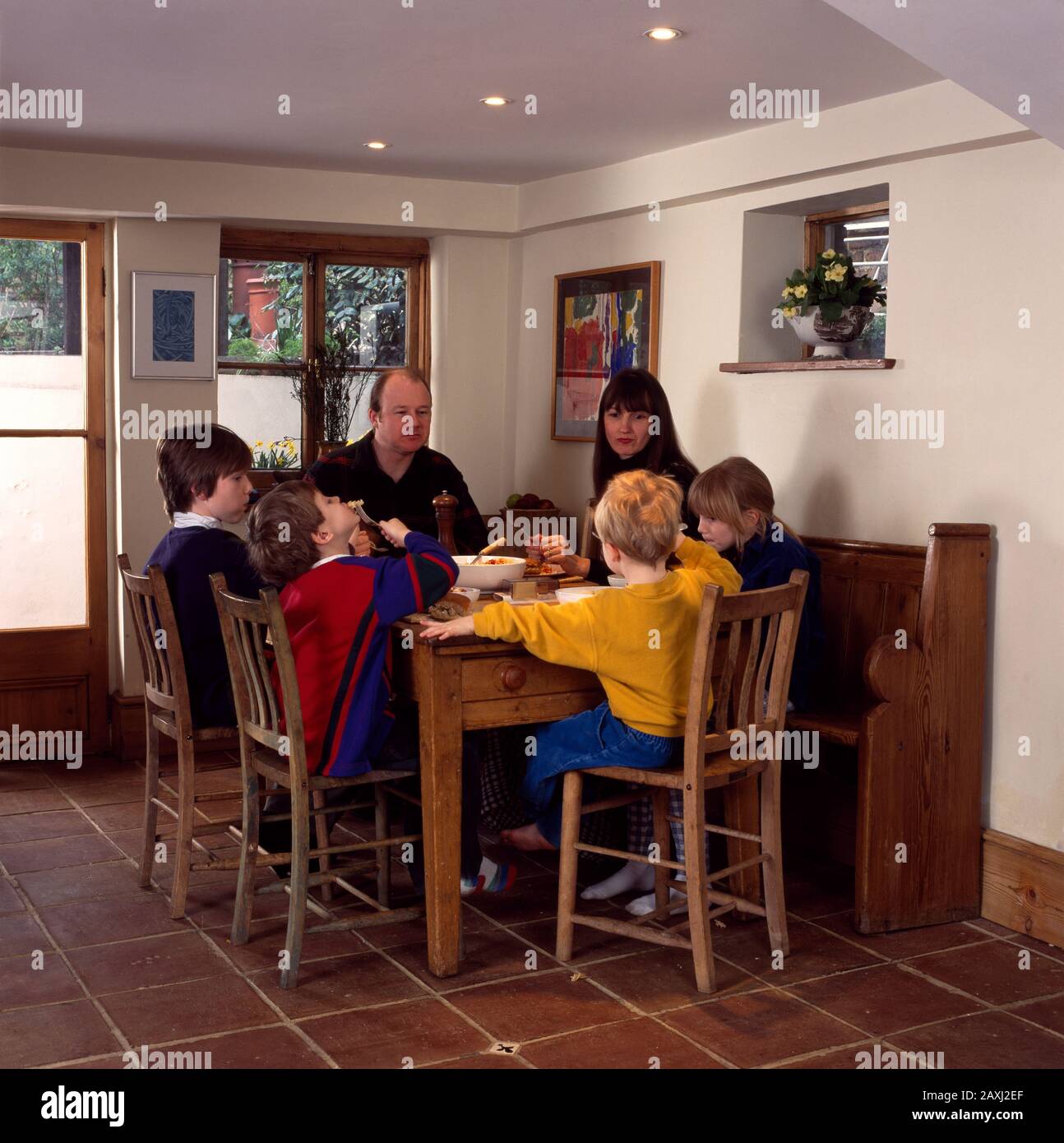 Family eating together in simple diningroom Stock Photo - Alamy