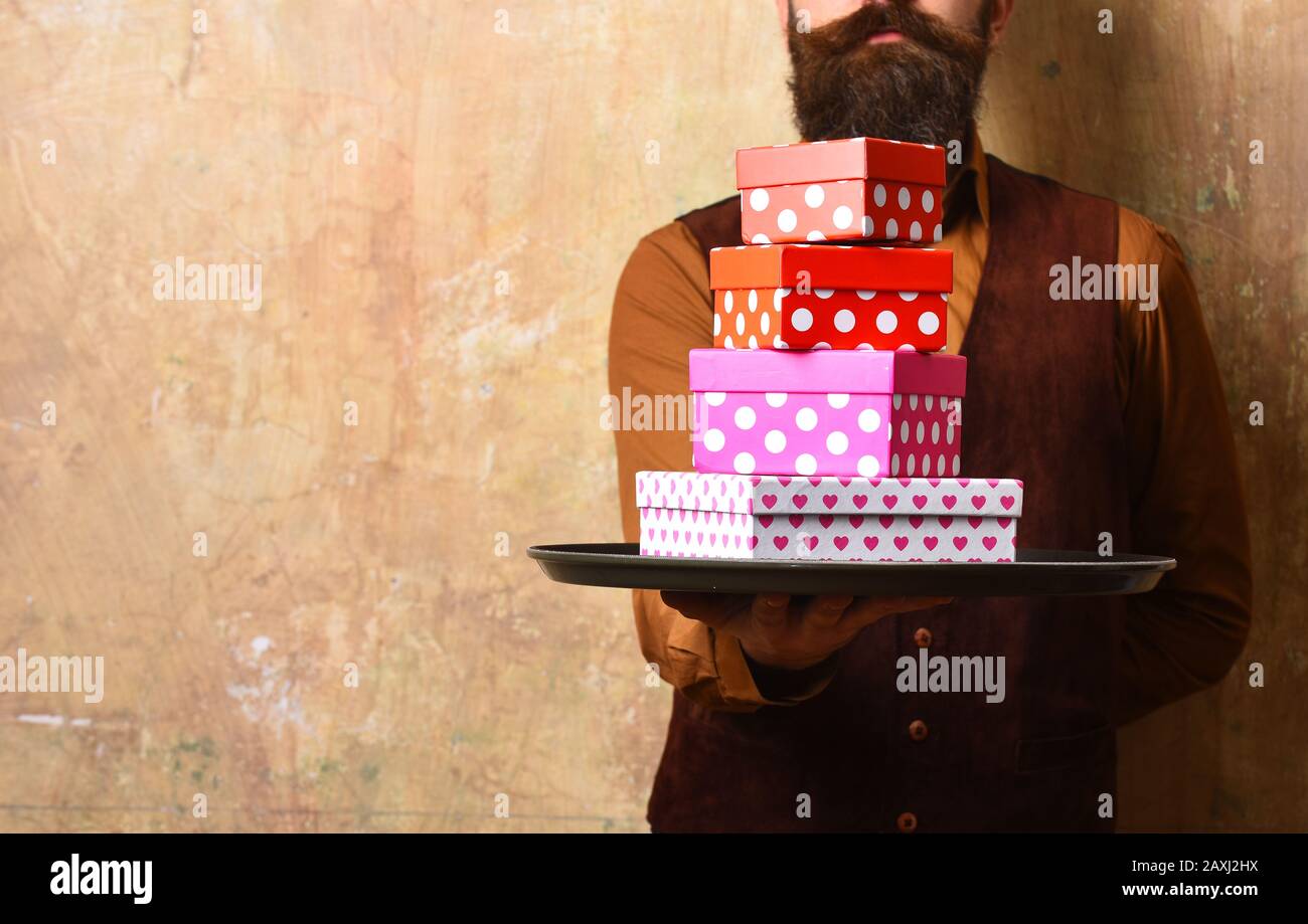 Waiter holding tray with gift boxes for birthday or Christmas on beige ...