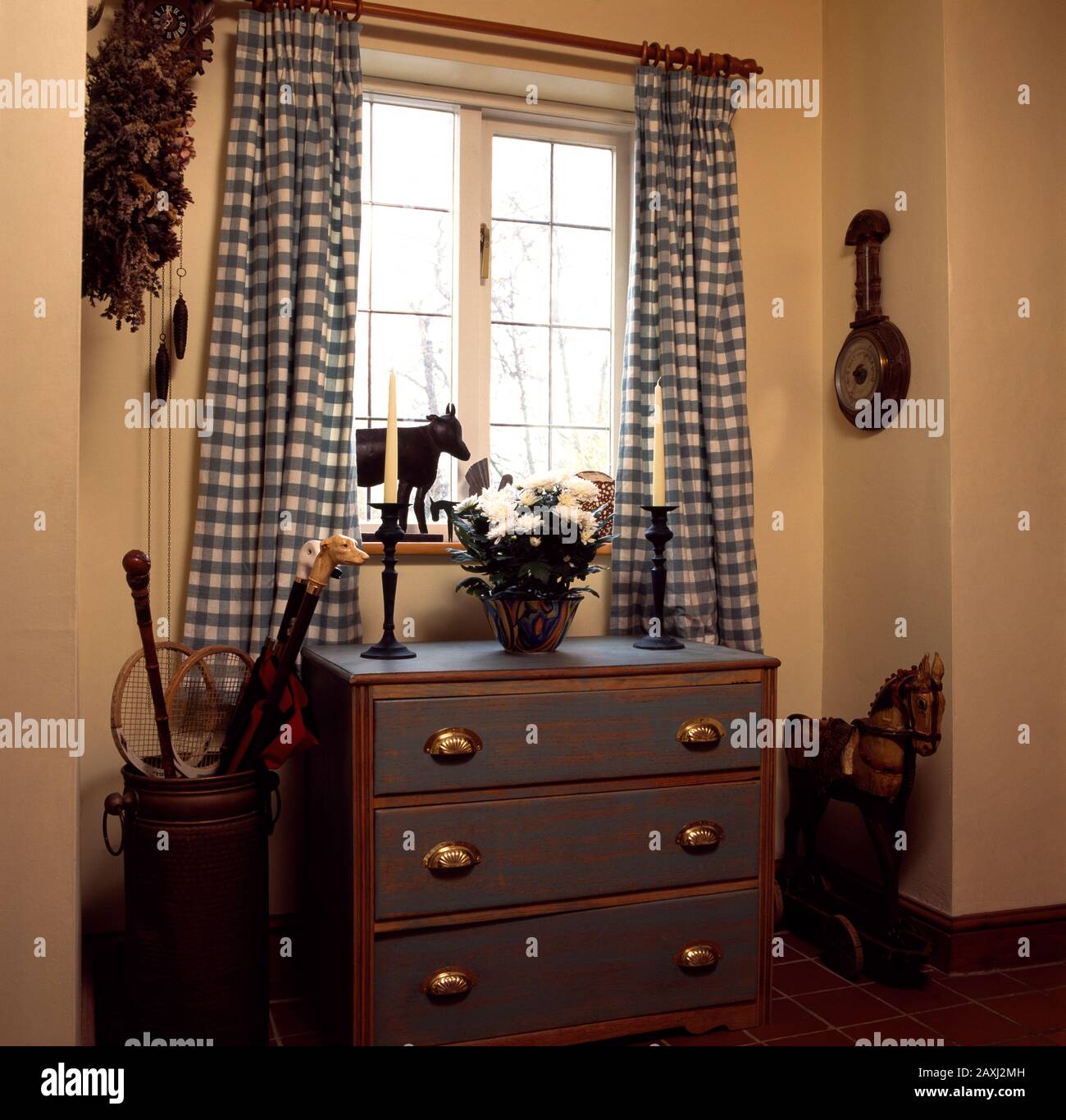 Closeup of check curtains on window with chest and sports storage Stock ...