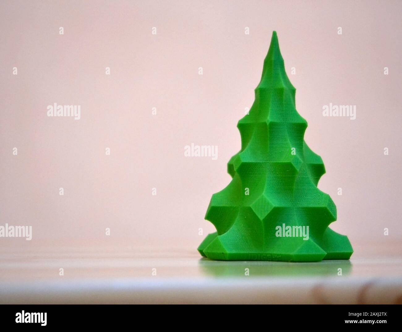 The model printed on a 3d printer. A small green tree is on the table ...