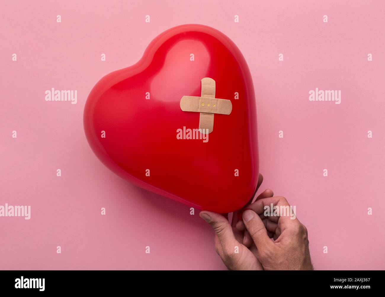 Female holding heart balloon with First Aid Band Plaster Strip Stock ...