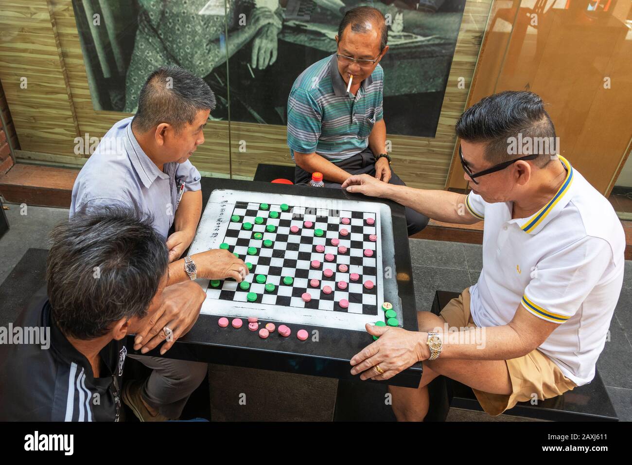 Local Chinese men playing the local and popular Singapore checkers in a ...