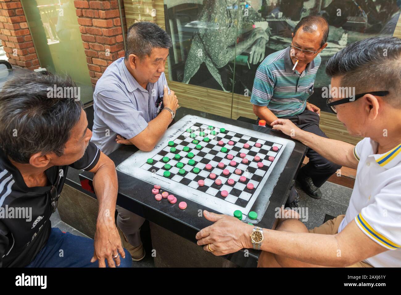 Local Chinese men playing the local and popular Singapore checkers in a ...