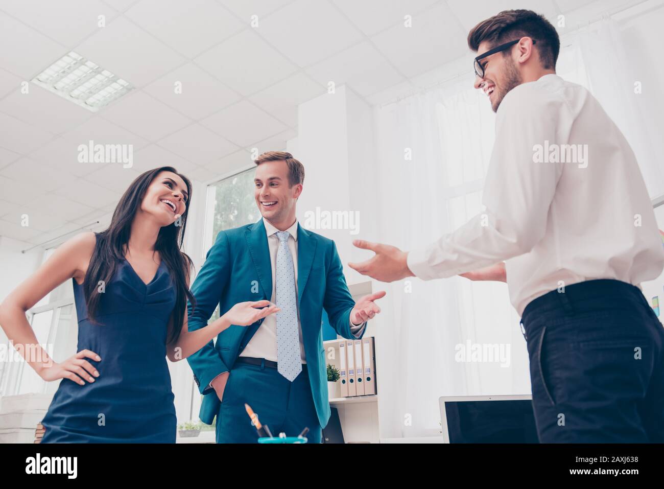 Portrait of three happy colleagues discussing new task and smiling ...