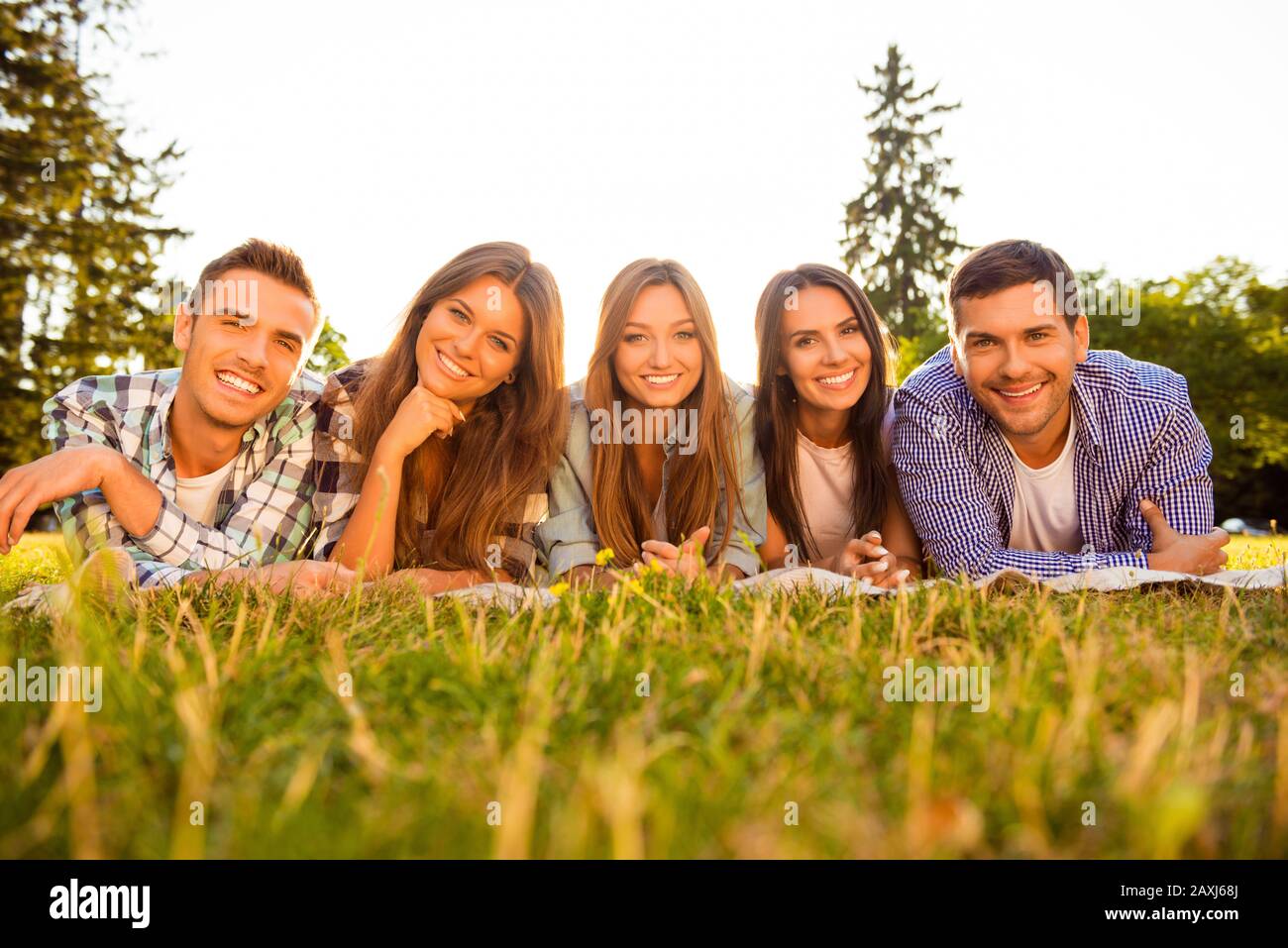 Portrait of five cheerful smiling friends lying on grass Stock Photo ...