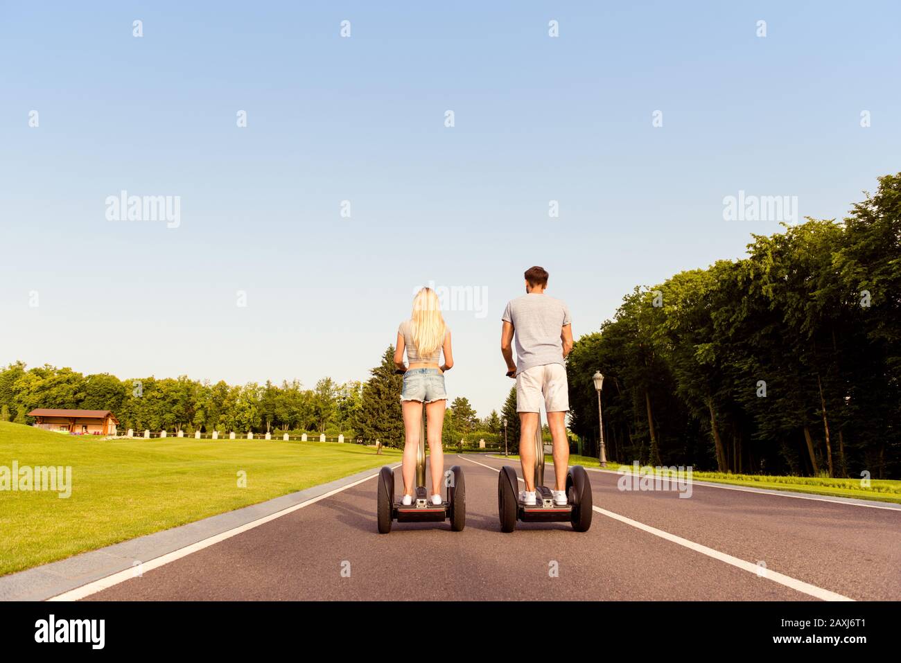 Back view of man and woman riding segways in the park Stock Photo - Alamy