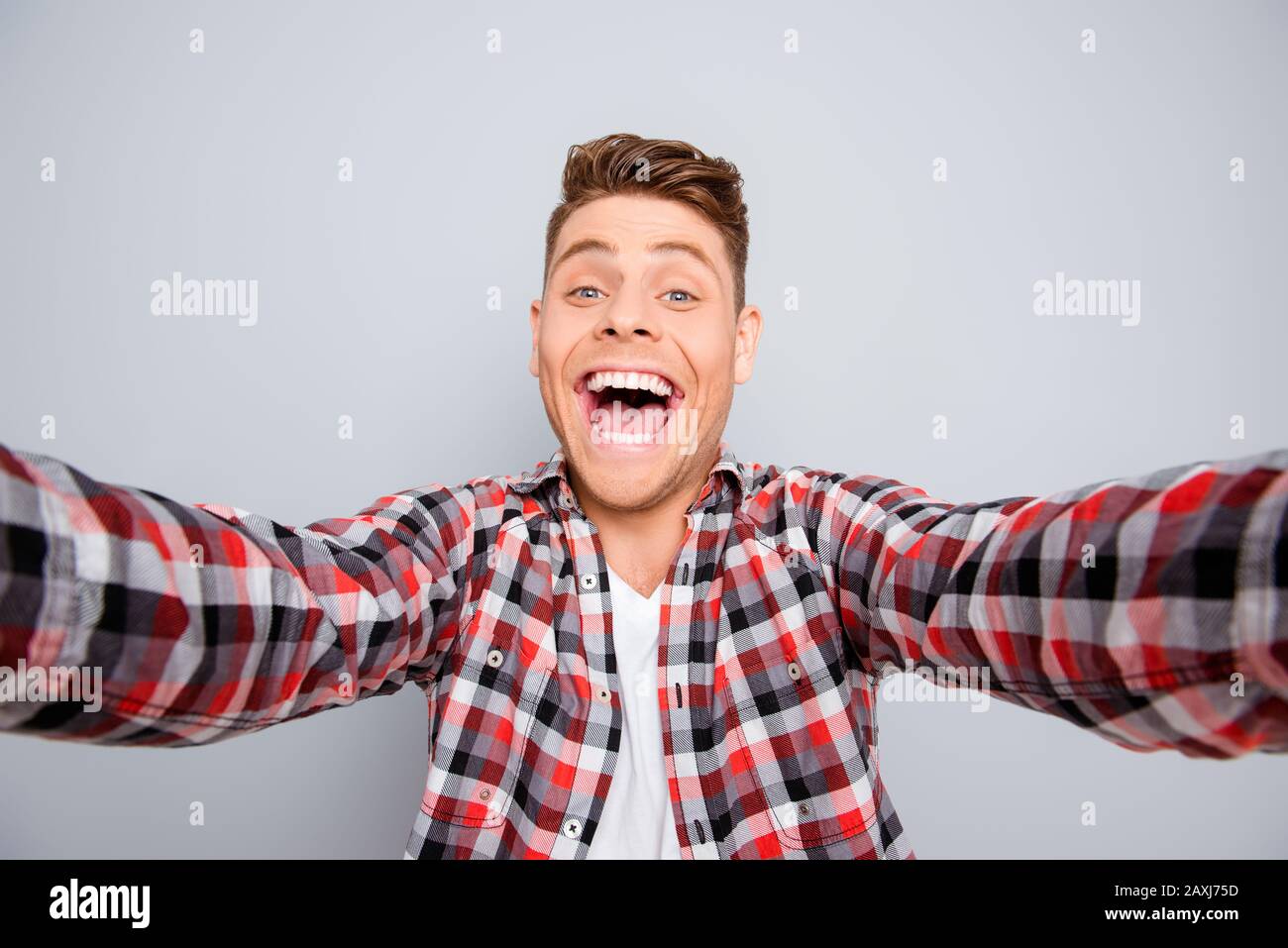 Handsome toothy comic man making selfie on gray background Stock Photo ...
