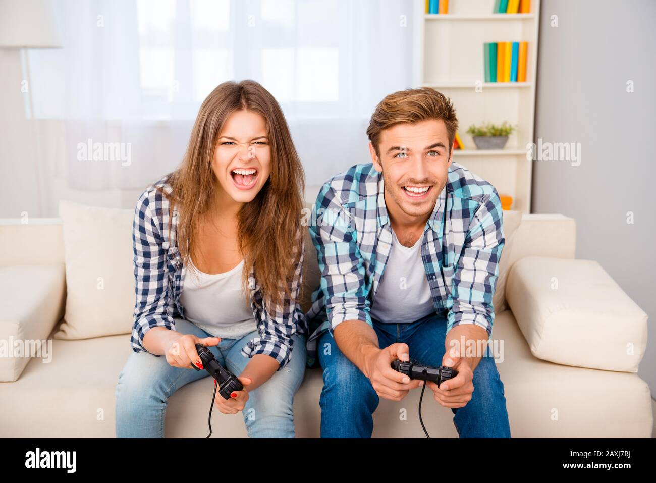 Happy man and woman with joysticks playing video games Stock Photo - Alamy