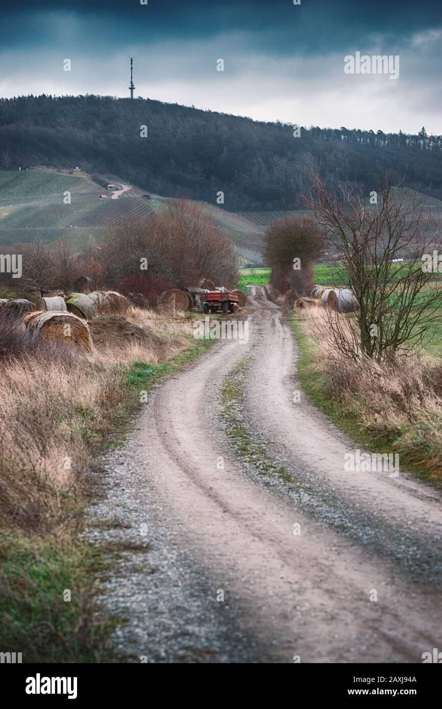 Long dirt road leading to the hill Stock Photo - Alamy