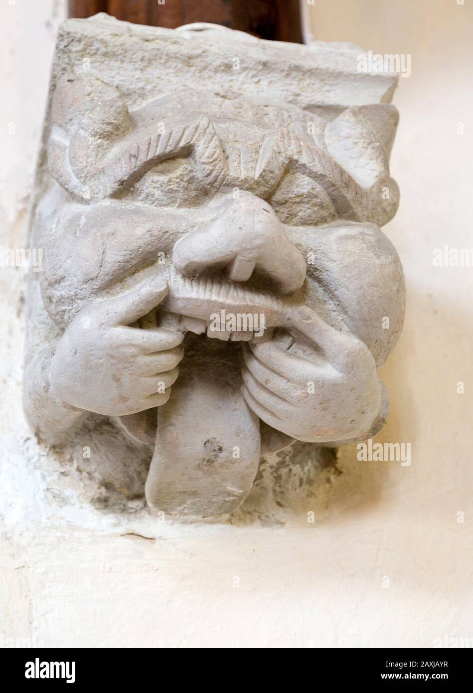 Grotesque corbel stone figure with mouth pulled open and rolling tongue ...