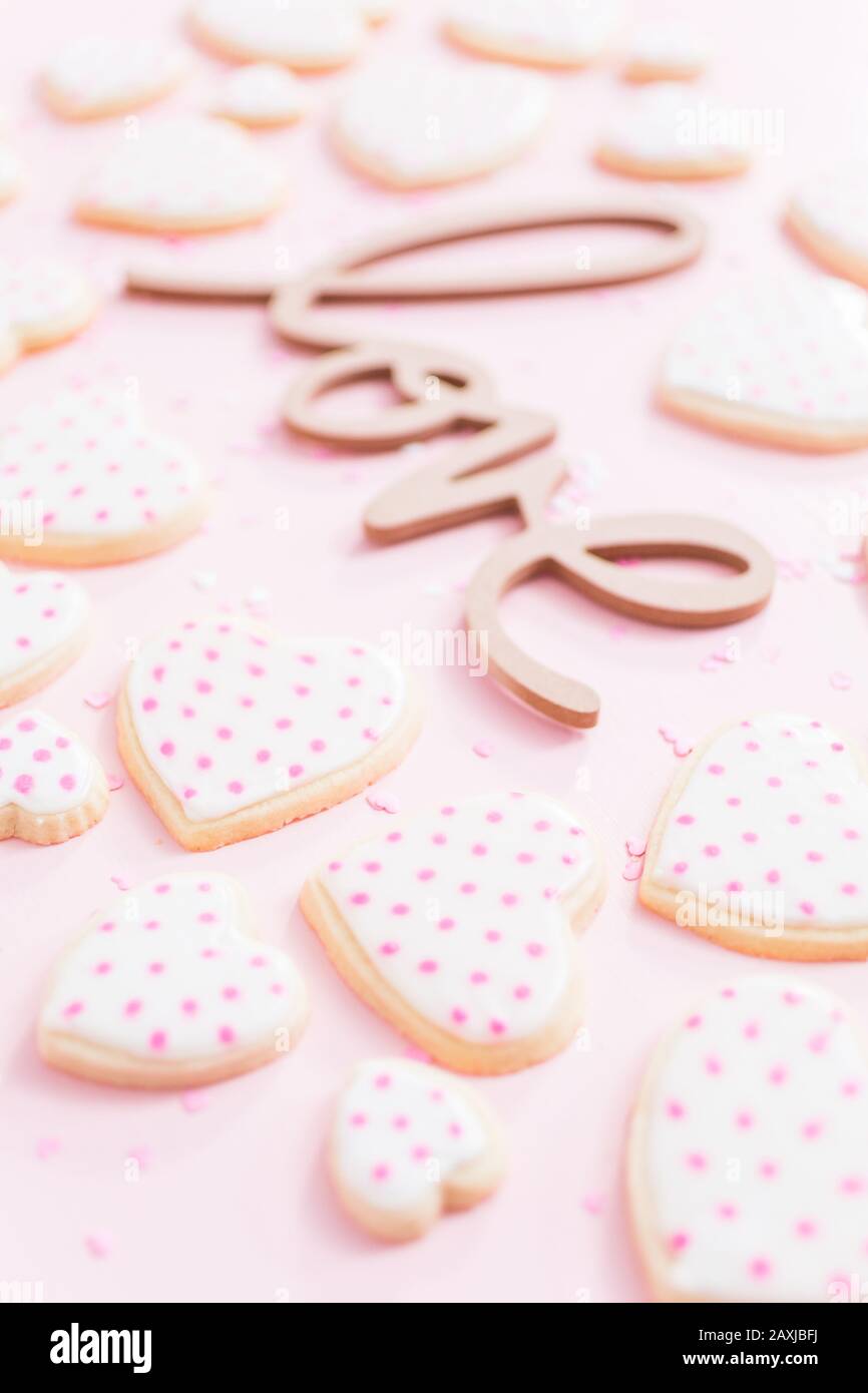 LOVE sign with heart shaped sugar cookies on a pink background Stock ...
