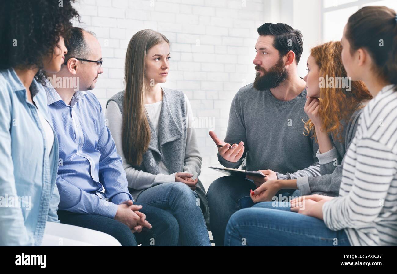 Therapist consulting patients of rehab group at therapy session Stock ...