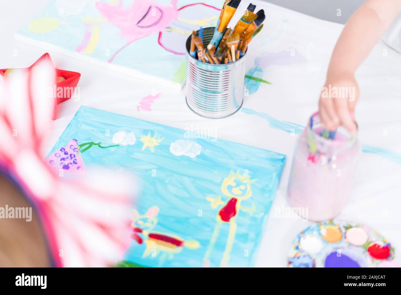 Little girls are painting on canvas with acrylic paint Stock Photo - Alamy