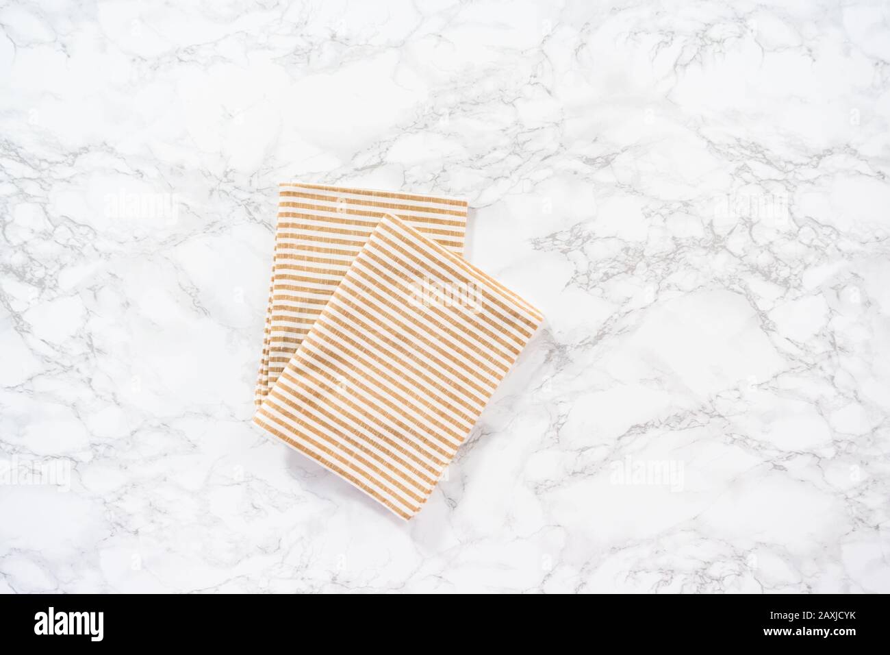 Flat lay. Kitchen towels with white and beige stripes on the marble ...