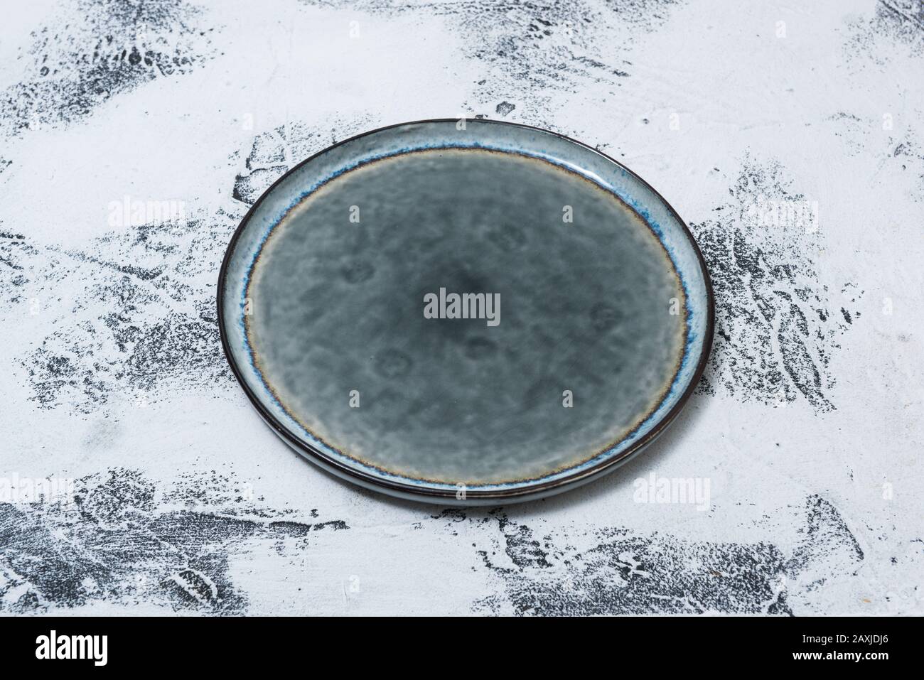 Round Plate on white abstract scraped wooden table background side view ...