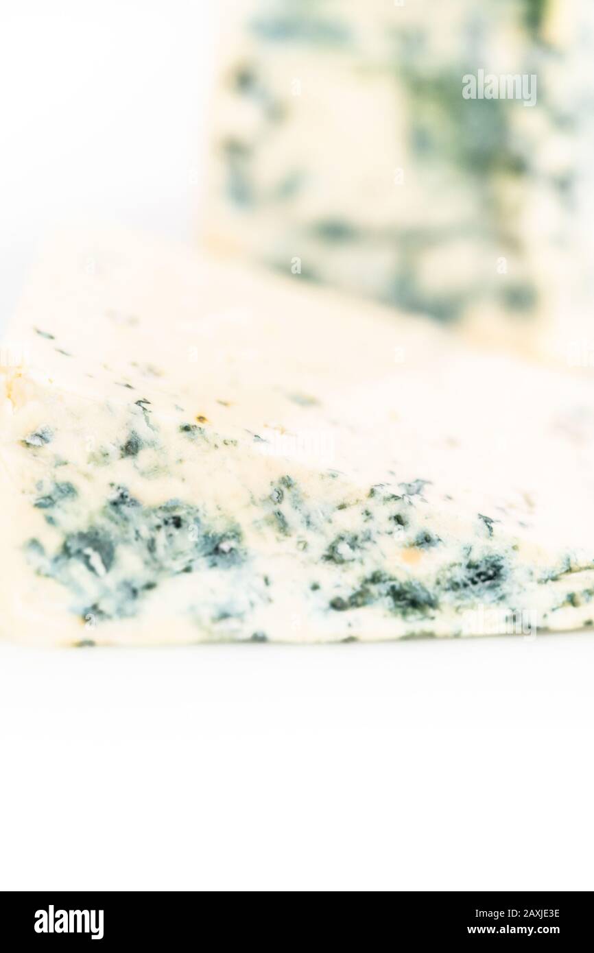 Large slice of blue cheese on a white background Stock Photo - Alamy