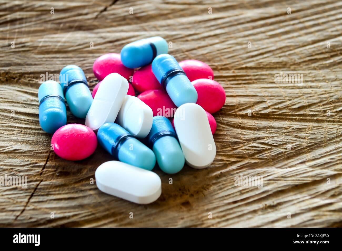 a pile of mixed tablets on a rustic bit of wood Stock Photo - Alamy
