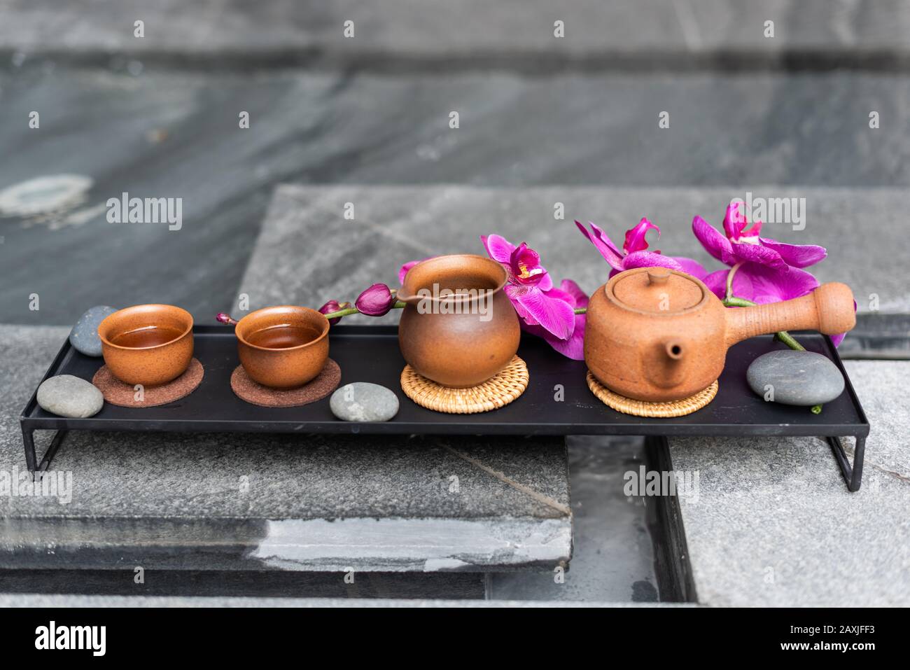 Traditional Chinese tea Set up with orchid and pebbles Stock Photo - Alamy