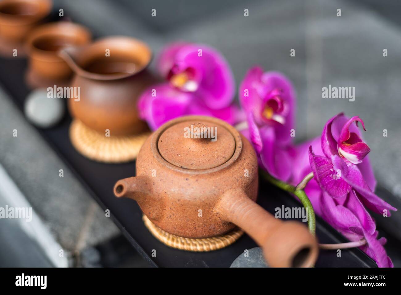 Traditional Chinese tea Set up with orchid and pebbles Stock Photo - Alamy