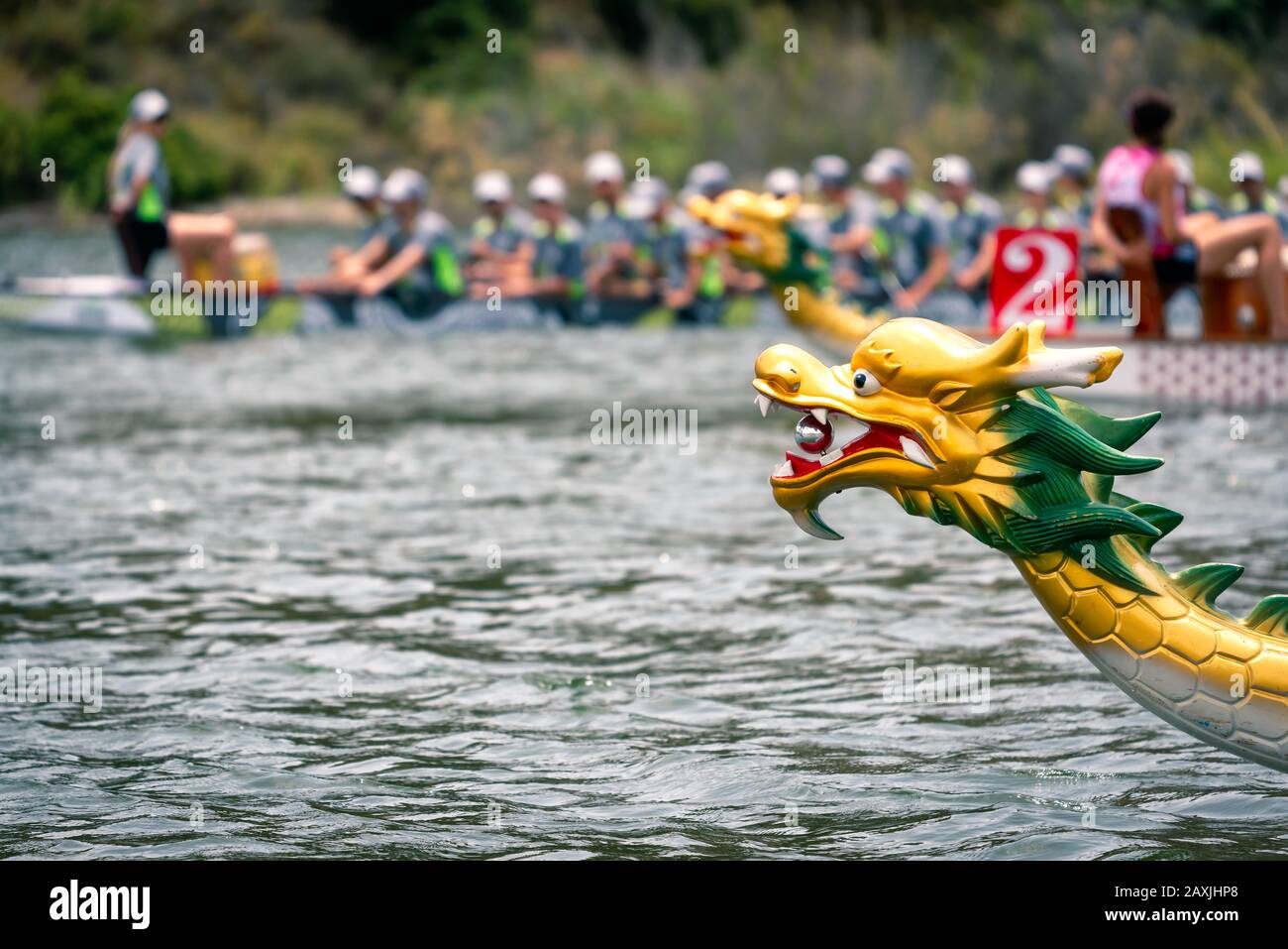 Dragon's head with dragon boat racing team at the back Stock Photo - Alamy