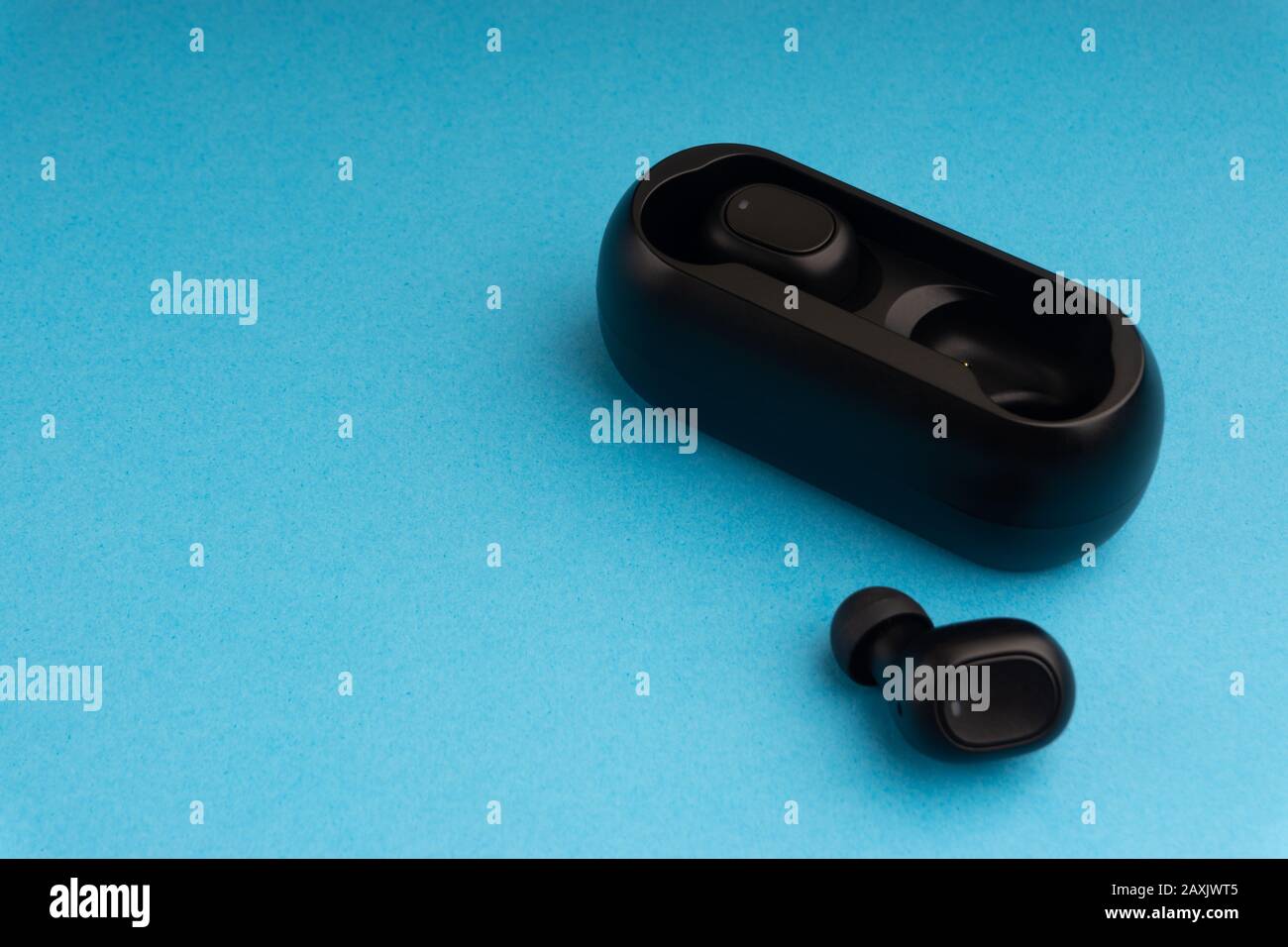 Wireless earbuds or earphones on blue background Stock Photo - Alamy