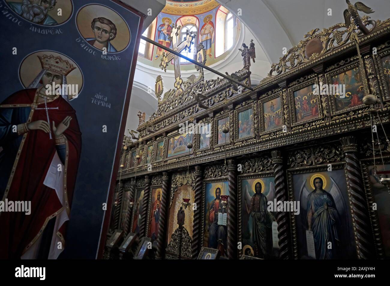 The iconostasis decorated with icons and religious paintings of the medieval cave church inside ...