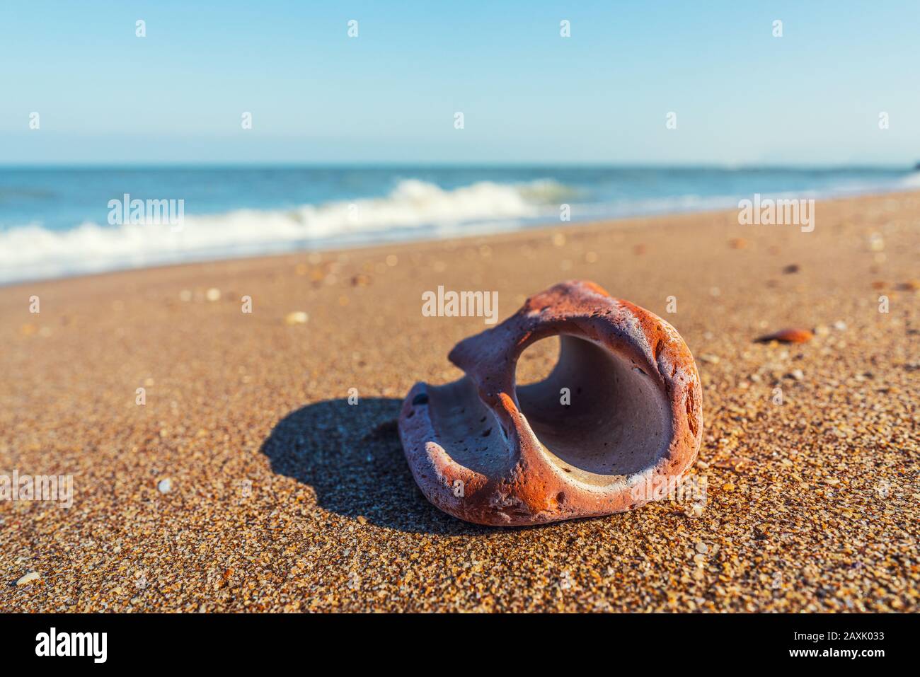 Bizarre stone with hole on the seashore Stock Photo - Alamy