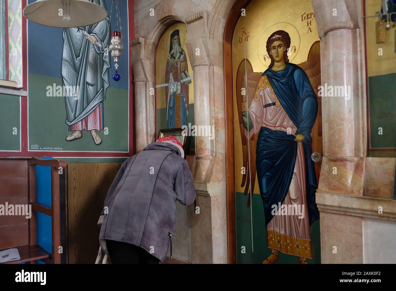 Eastern Orthodox Pilgrim kissing a religious icon as she prays inside ...