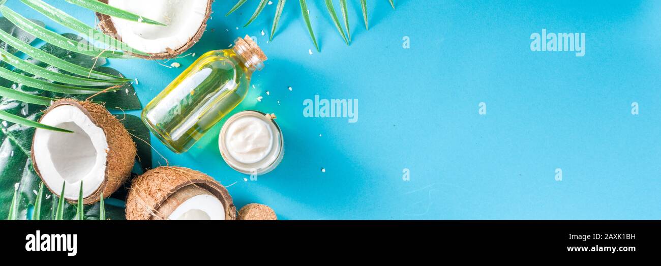 Coconut oil in glass jar with tropical leaves and fresh coconut ...