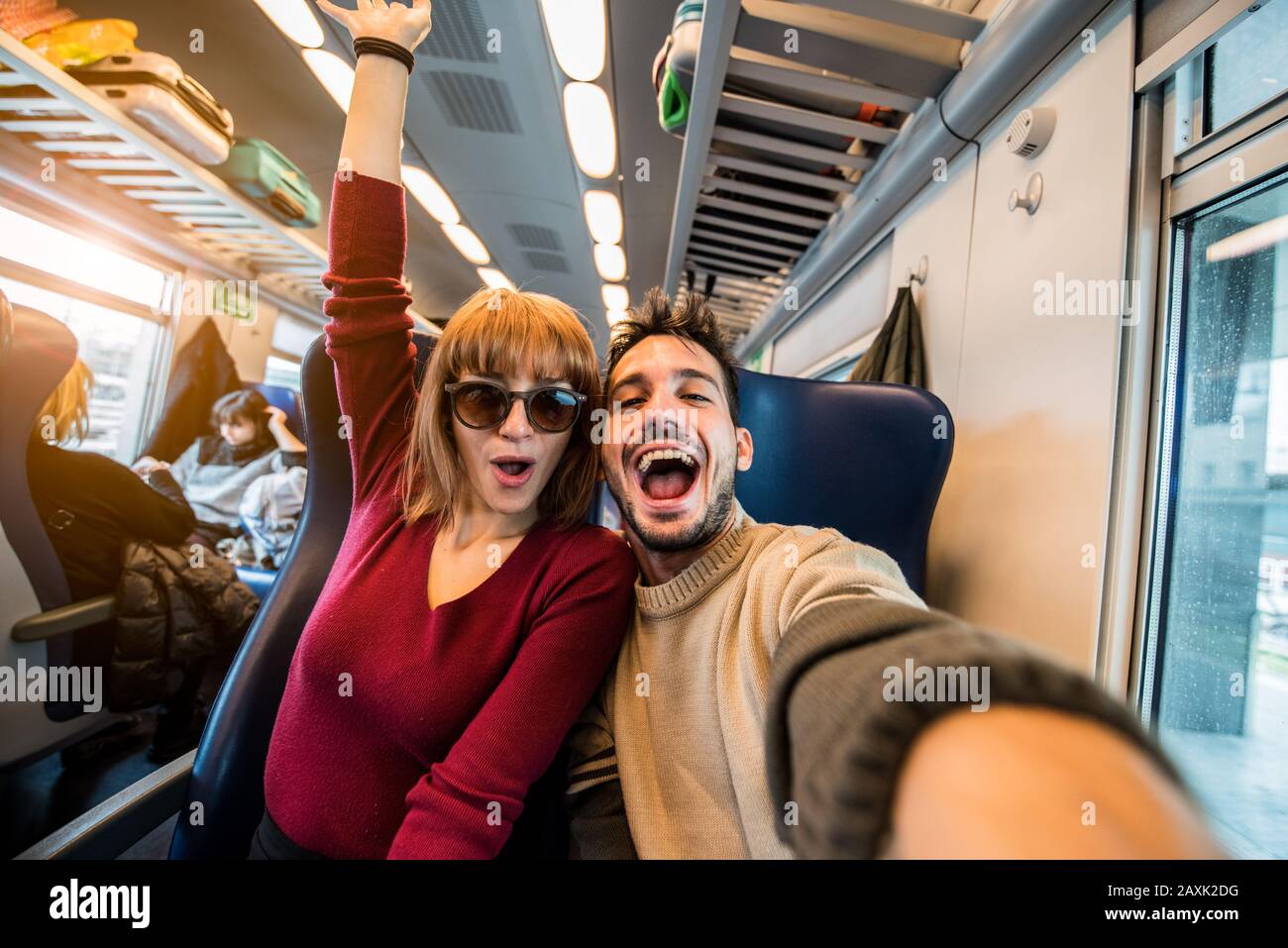 Happy And Excited Couple Taking A Selfie Sitting On A Train At Vacation