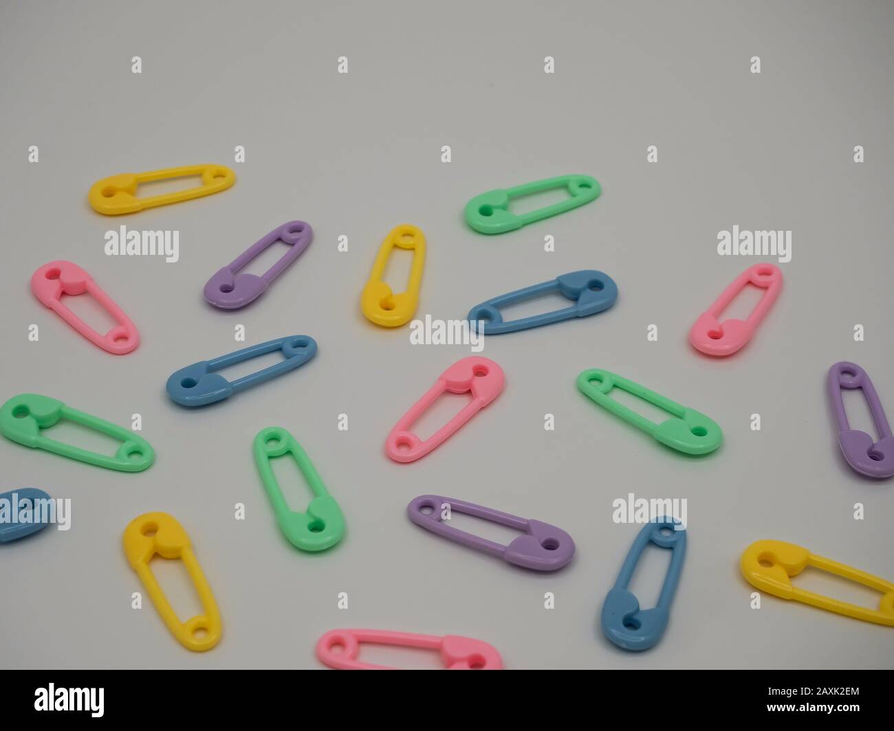 Colorful plastic safety pins for a baby theme on a white background ...