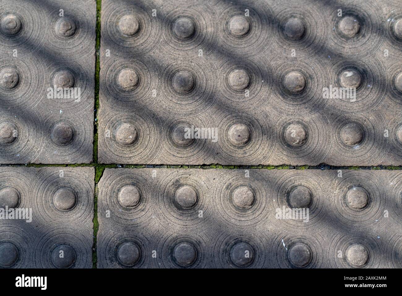 Grey paving slabs with small circle detail, sunlight and shadow ...