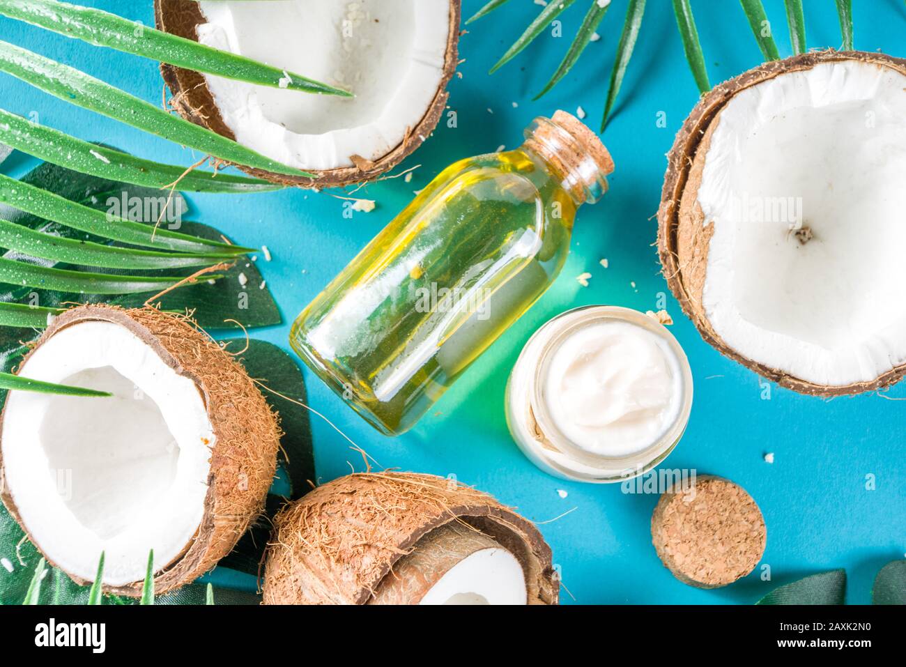 Coconut oil in glass jar with tropical leaves and fresh coconut ...