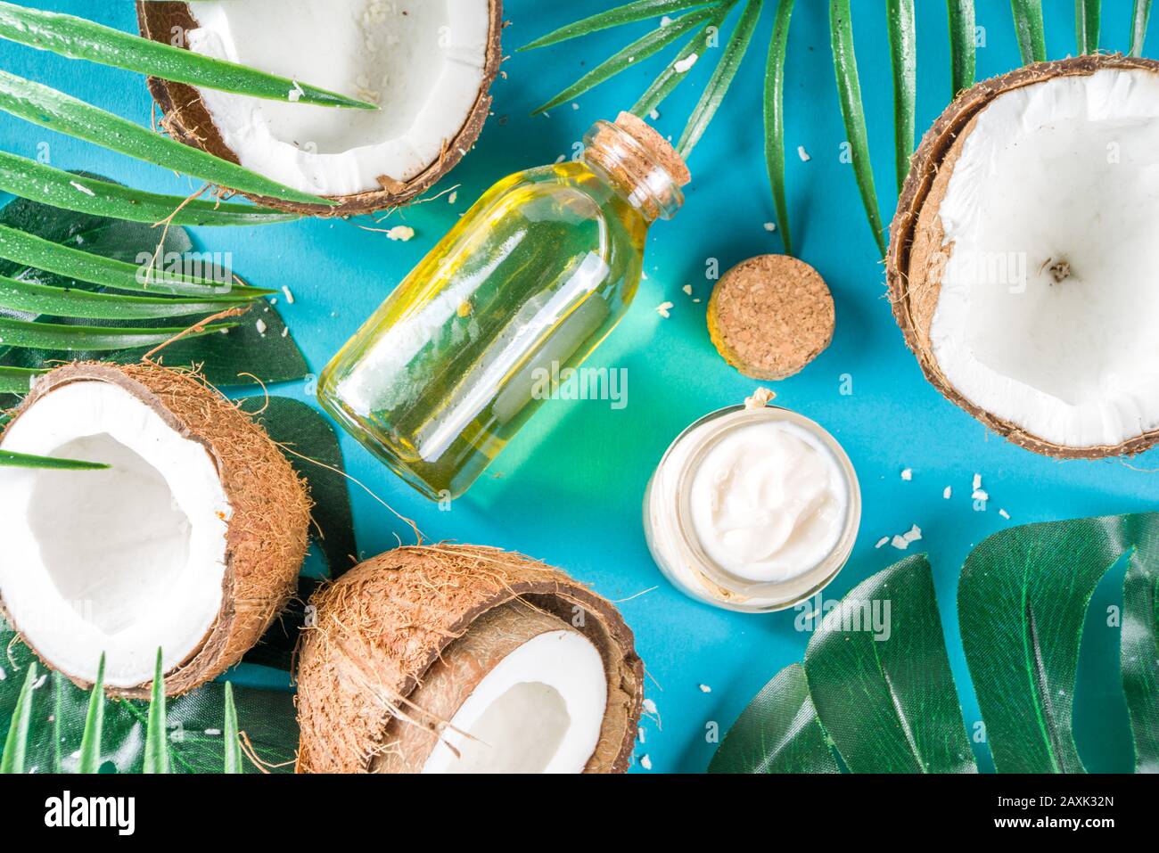 Coconut oil in glass jar with tropical leaves and fresh coconut ...